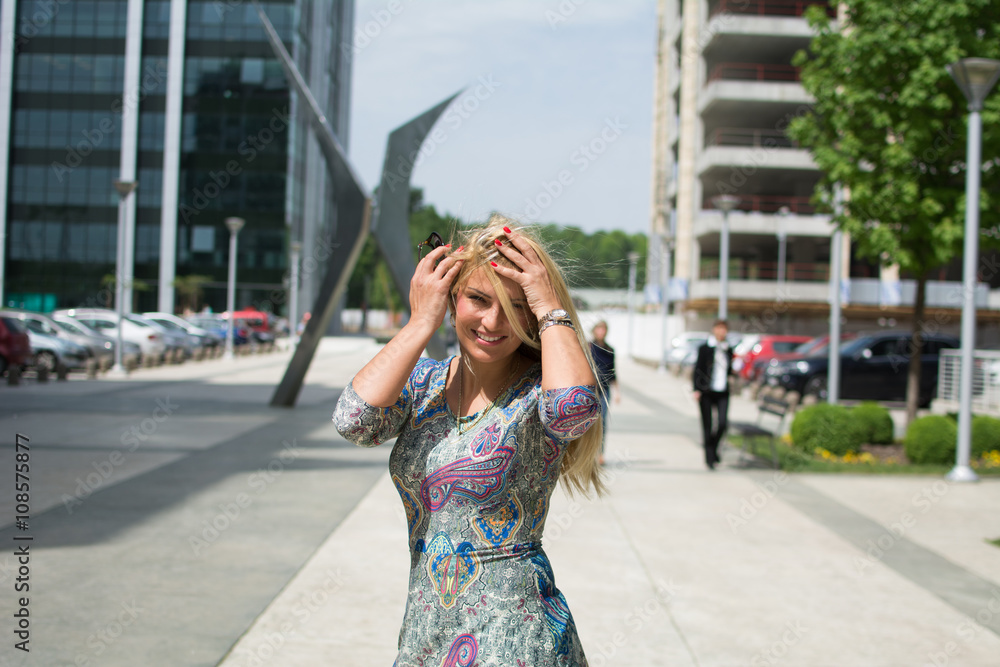 beautiful girl with long blonde hair outdoor, with hands on her head ...