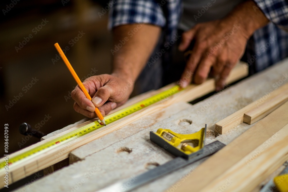 Carpenter marking on wooden plank with pencil Stock Photo | Adobe Stock