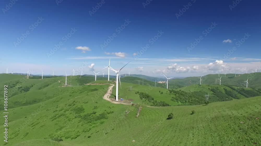 Aerial of wind farm on the mountain top creates clean energy and a ...