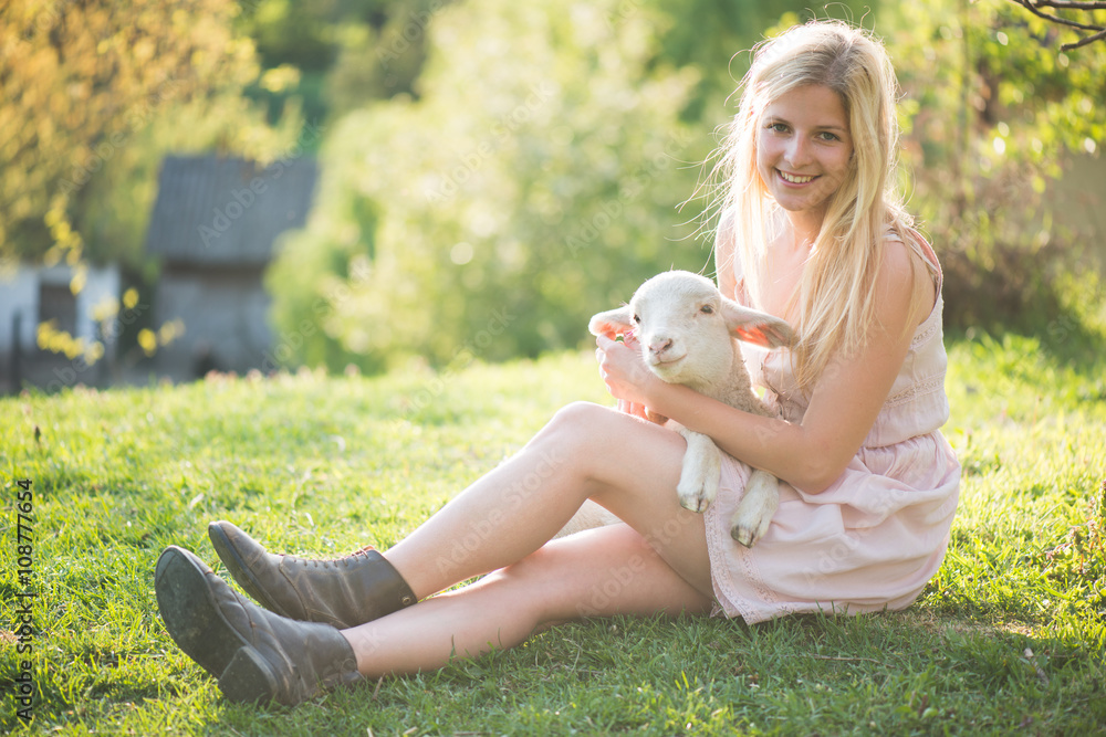 Farmer woman posing outdoor with cute baby lamb. Cute young lamb at her ...