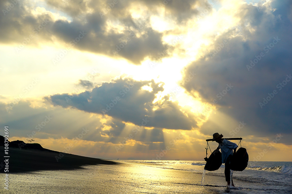 Silhouette of traditional salt farmer at Kusamba Bali Island, Indonesia ...