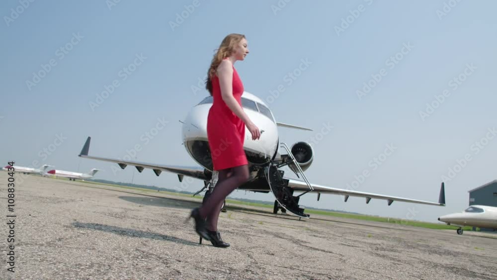 Vidéo Stock Attractive brunette in a red dress and wearing high heels ...