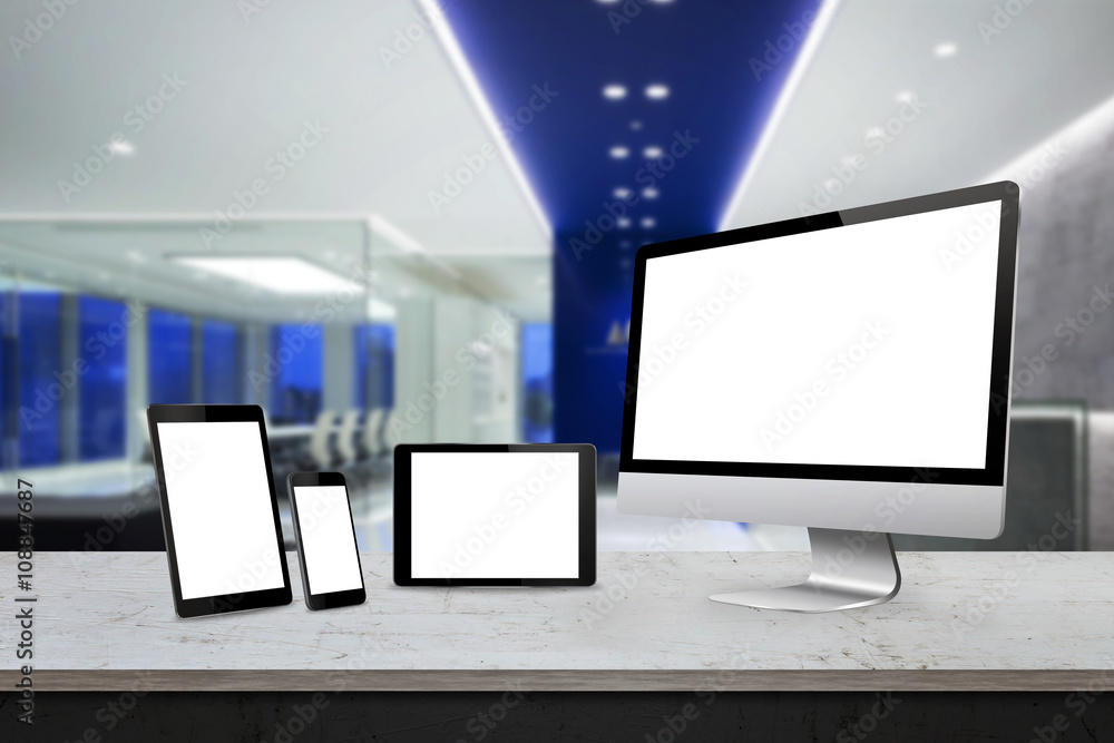 Responsive display devices on table in office. Isolated white screen ...