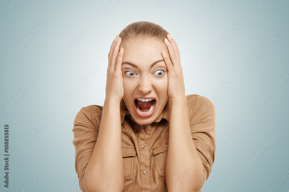 Close up shot of stressed and shocked young blonde businesswoman screaming with desperate and ...