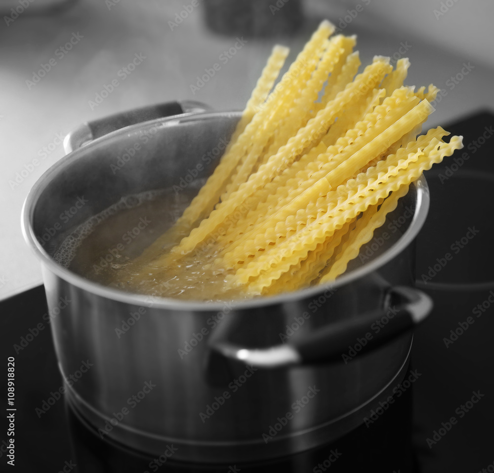 Boiling pasta in pan on electric stove in the kitchen Stock Photo ...