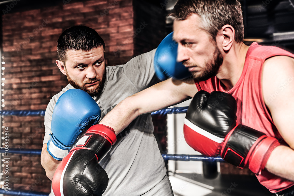 Two athletes boxers sparred in the ring. Kicking and blocking the hit ...
