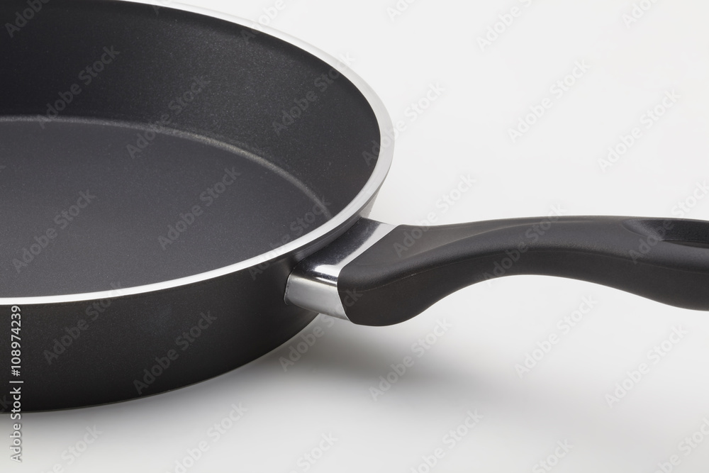 Side view of empty frying pan with teflon coating on white background ...