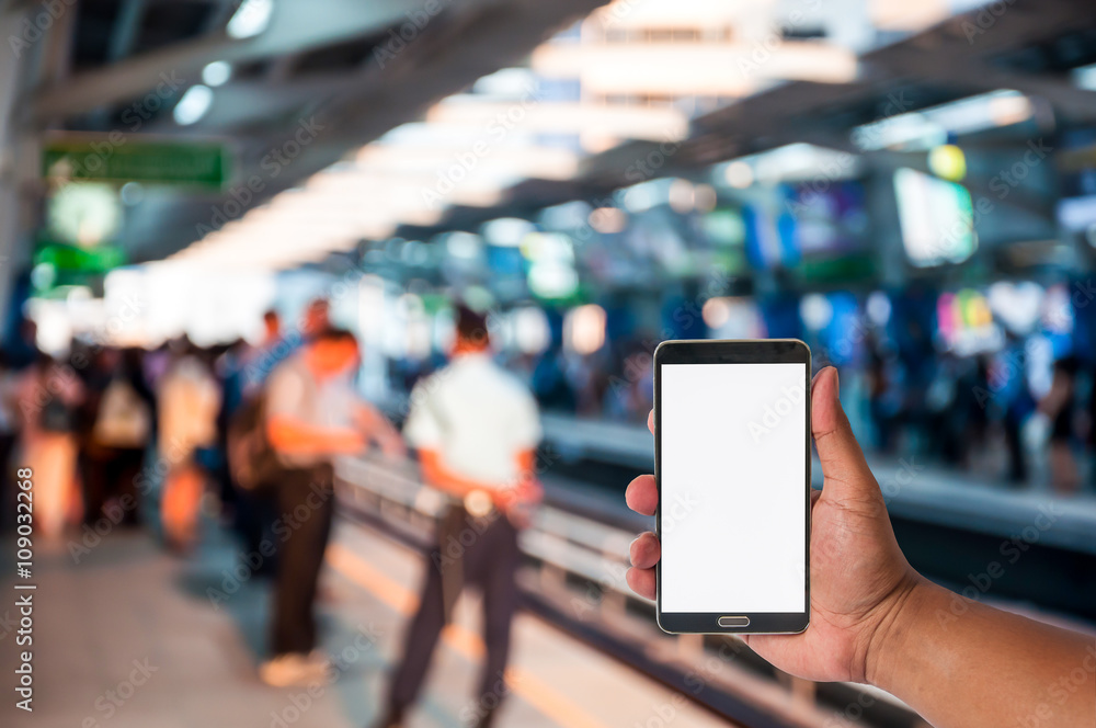 hand of man hold mobile phone over blurred of people waiting at sky ...