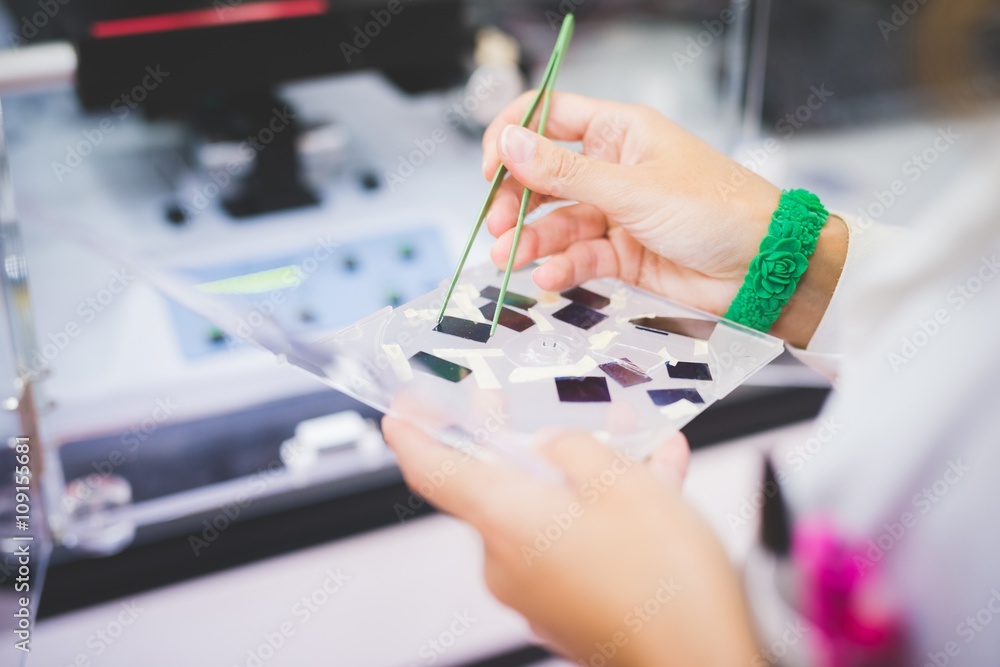 Female scientist using FTIR spectrophotometer, taking thin film sample ...