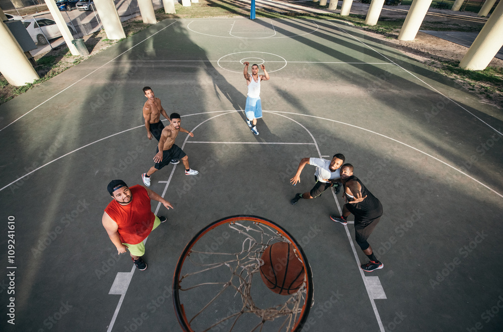High angle view of men on basketball court watching basketball going ...