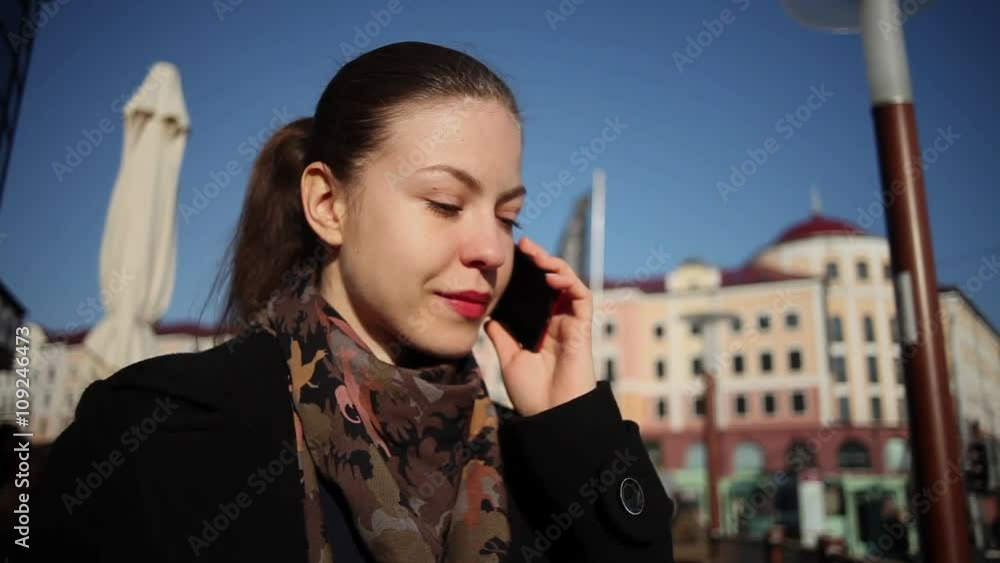 Young woman talking on the phone, crying, wiping tears on the ...