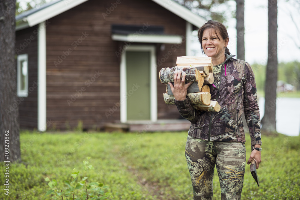 Woman carrying firewood Stock Photo | Adobe Stock