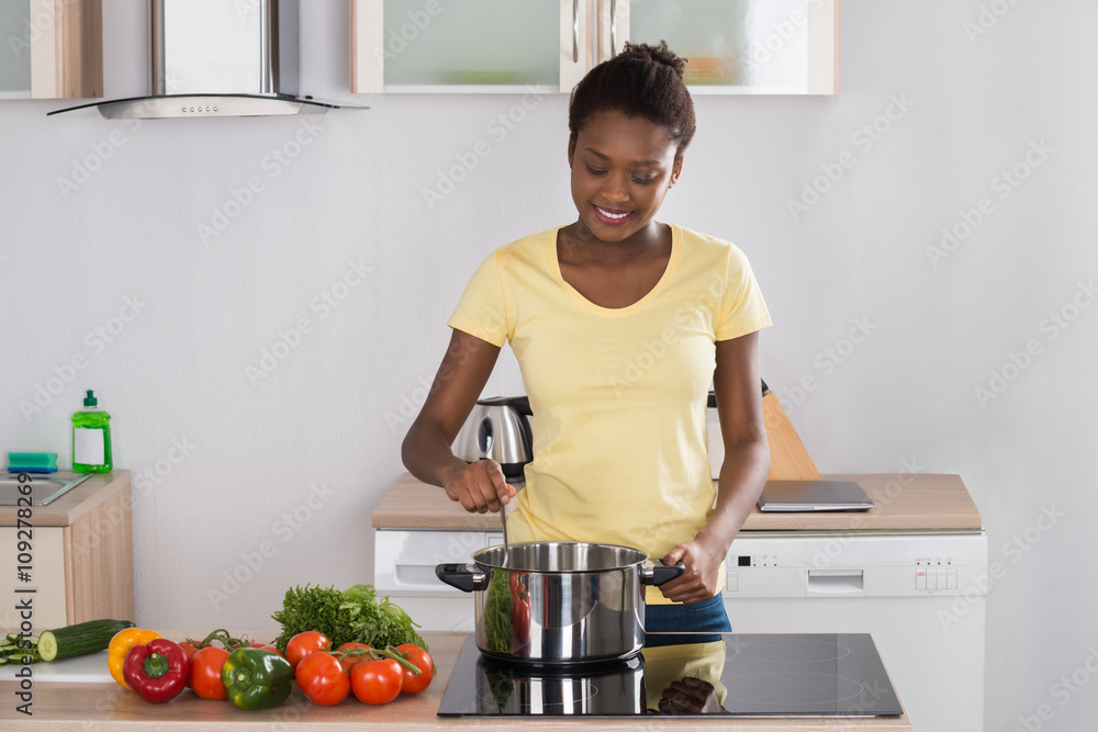 Woman Cooking Meal In Kitchen Stock Photo | Adobe Stock