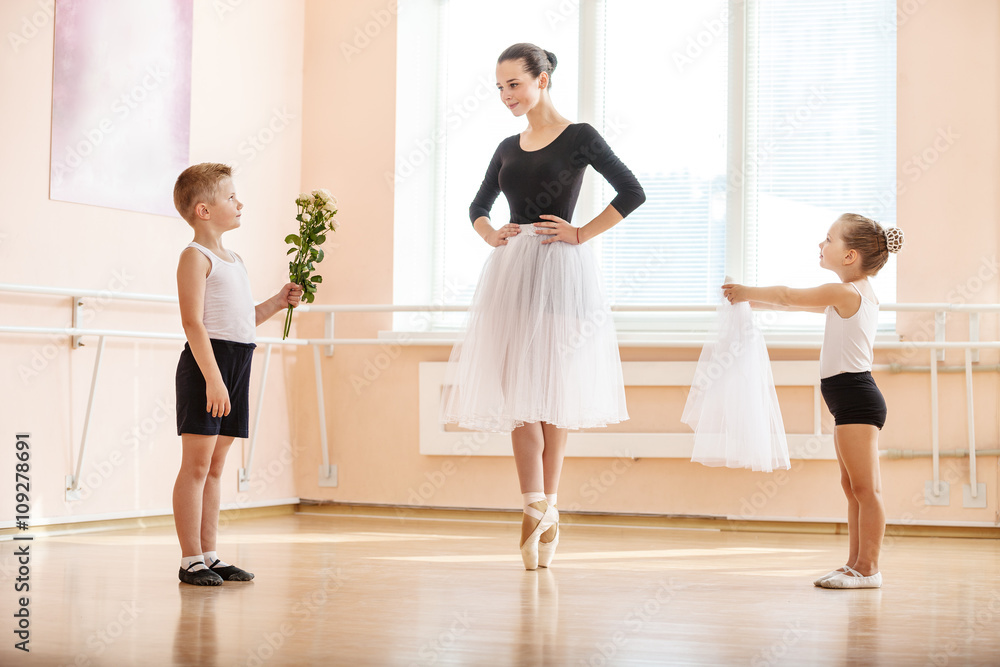 At ballet dancing class: young boy and girl giving flowers and veil to ...