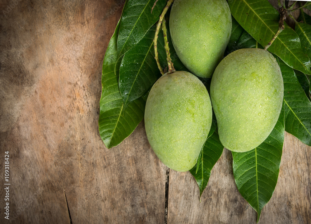 Green mango on wood background Stock Photo | Adobe Stock