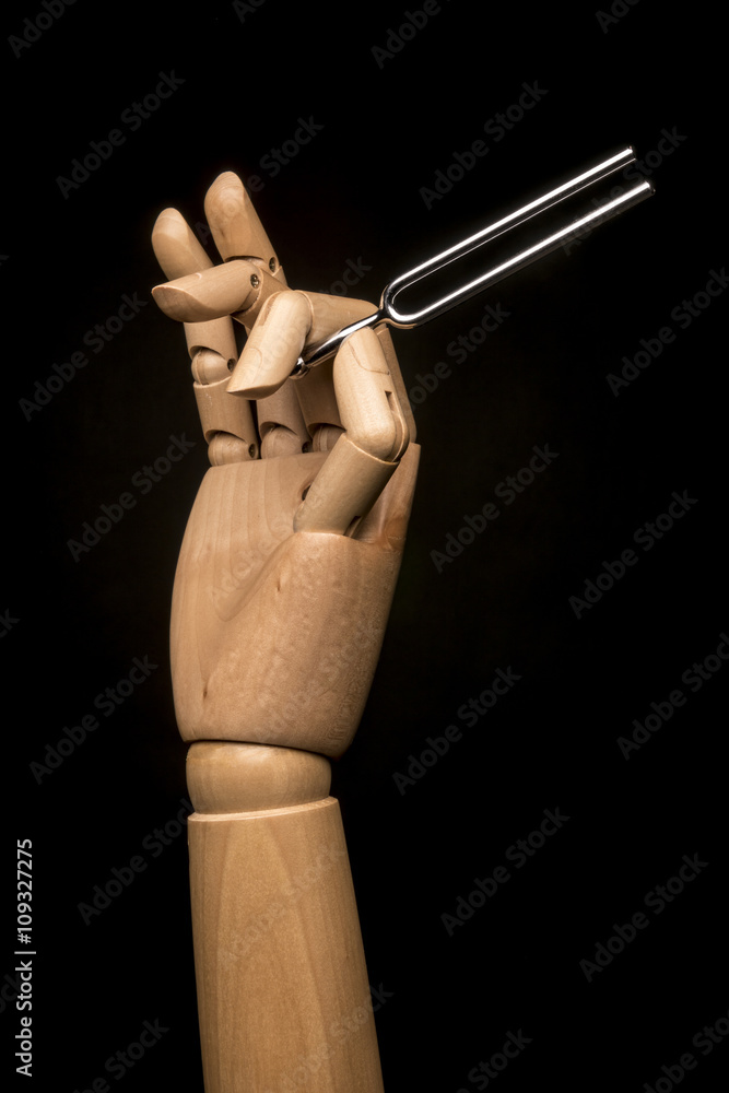 Hand sets the tone with a pitch fork. On black background. Stock Photo ...