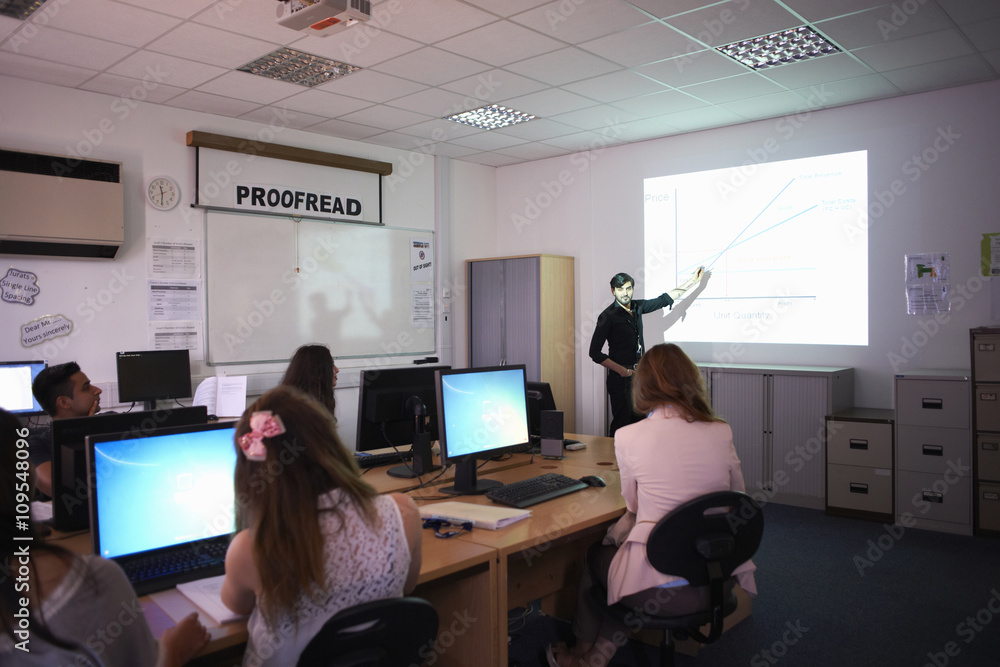 Computer teacher teaching in classroom Stock Photo | Adobe Stock
