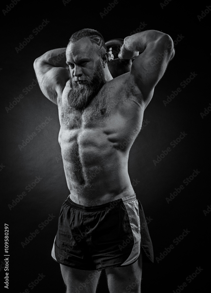 Bodybuilder with a beard lifts a heavy kettlebell Stock Photo | Adobe Stock