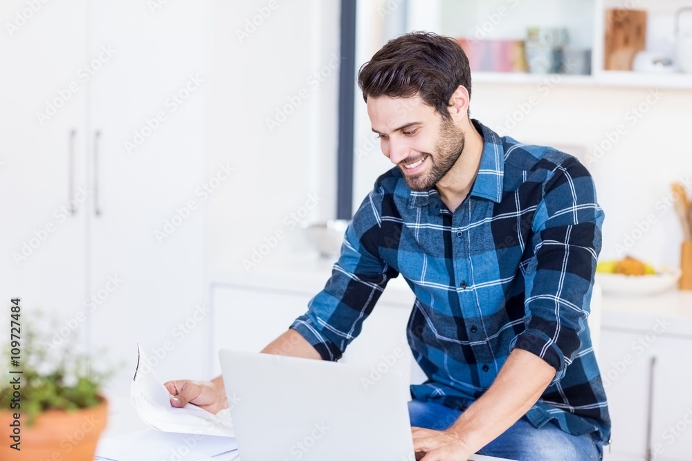 Young man paying his bill online with laptop Stock Photo | Adobe Stock
