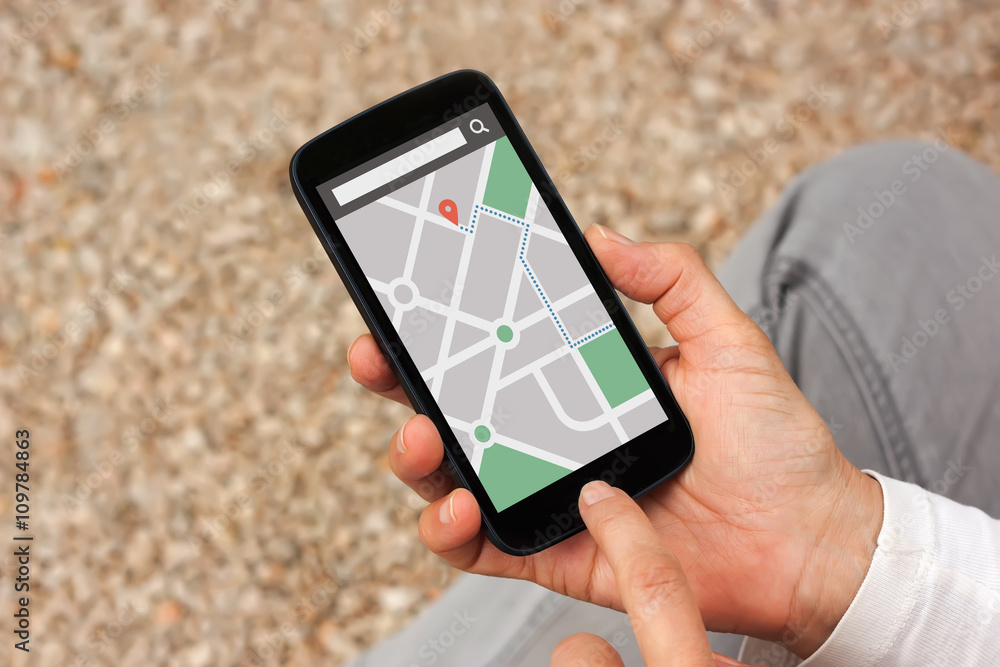 Hands holding smart phone with map gps navigation application on screen. All screen content is ...