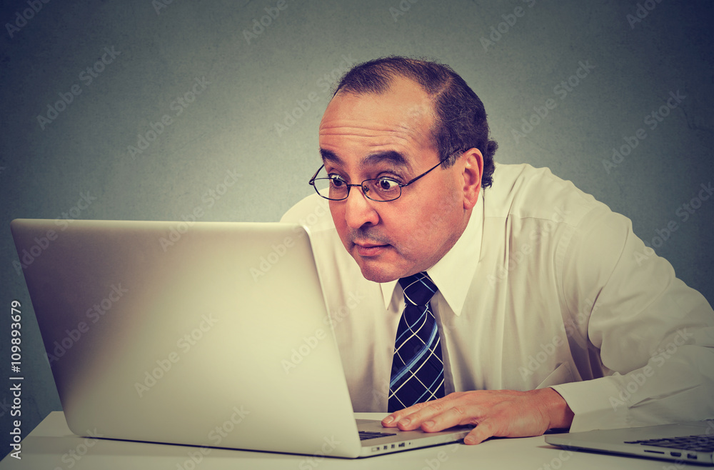 middle aged shocked business man sitting in front of laptop computer ...