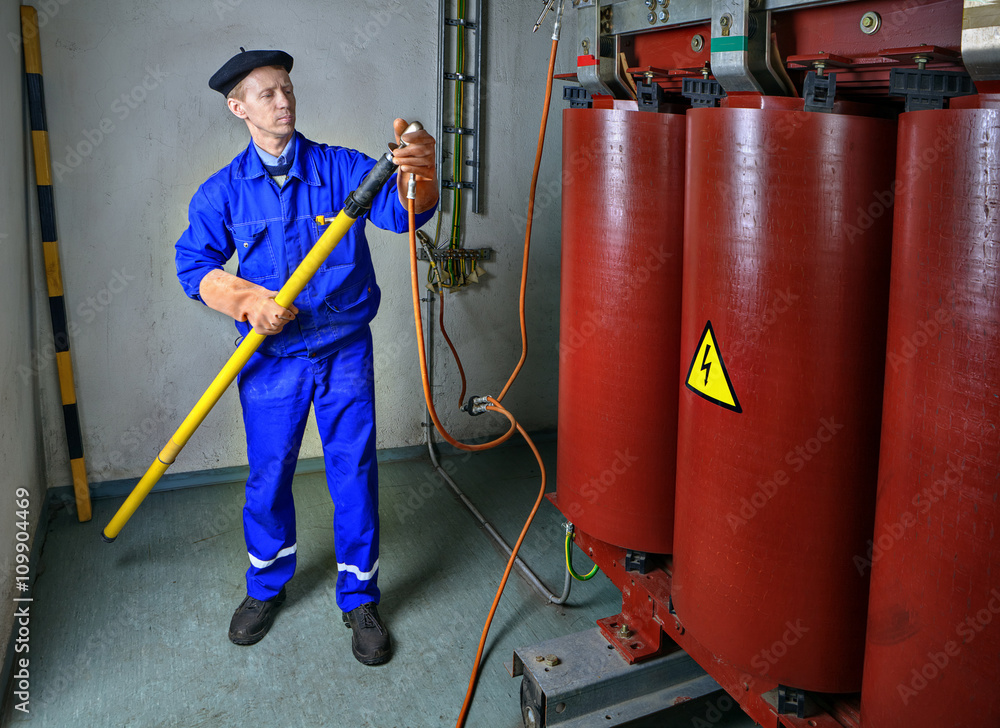 Electrician uses an insulating stick Earthing transformer. Stock Photo ...