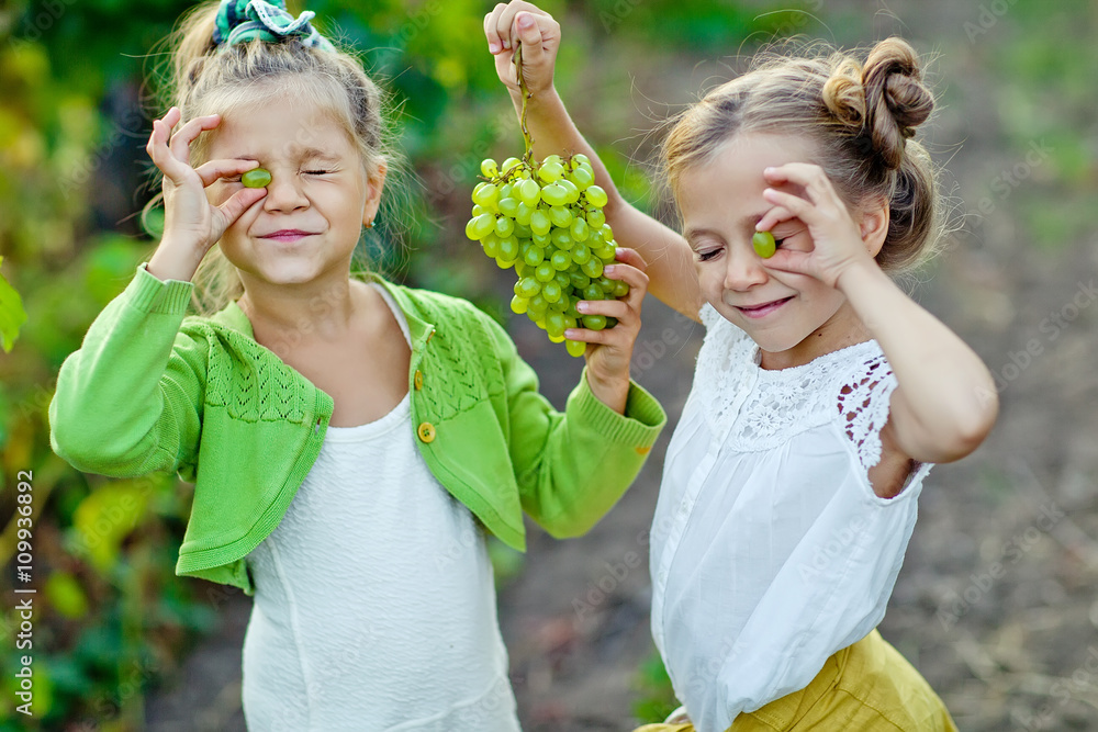 Little kids are eating grapes Stock Photo | Adobe Stock