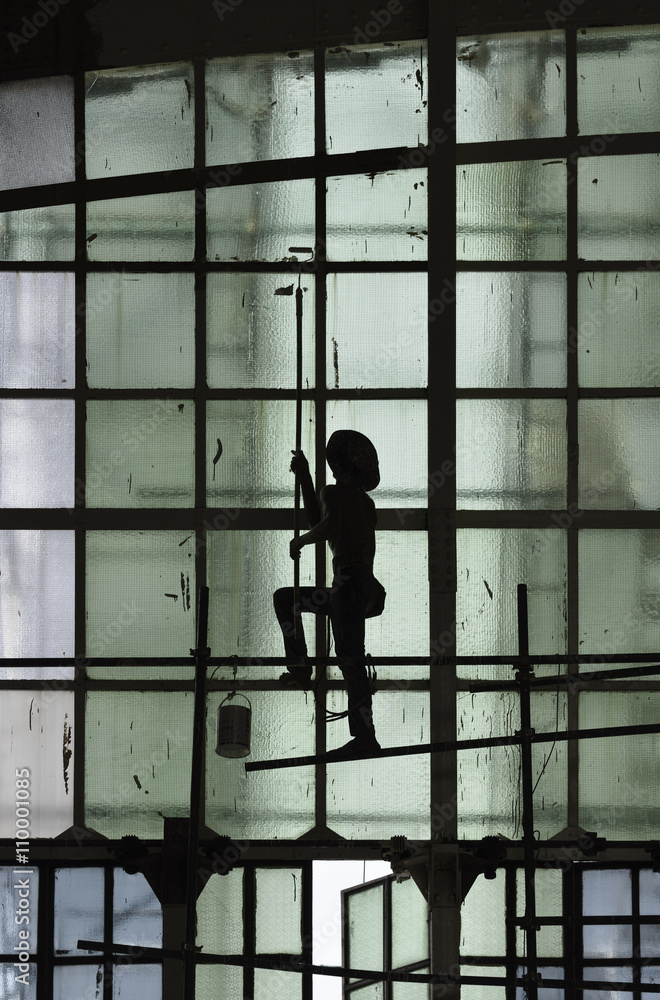 Back view of man painting on green glass window wall with paint Stock ...