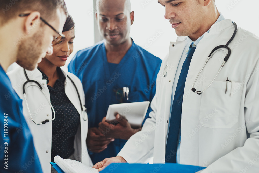 Team of multiracial doctors reading patient notes Stock Photo | Adobe Stock