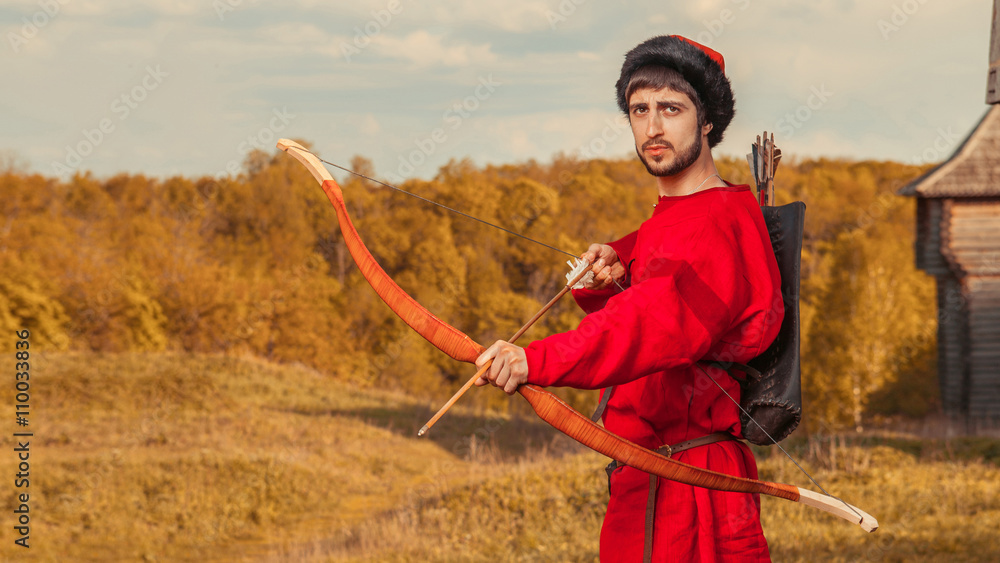Russian archer with the wooden bow in traditional red suit and f Stock ...