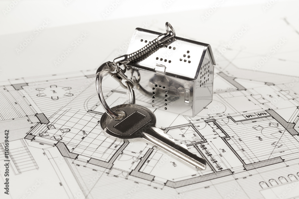 key with keychain in the form of a silver-colored house on a background ...