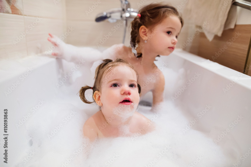 Two little girls having bath with bubbles in bathtub Stock Photo ...