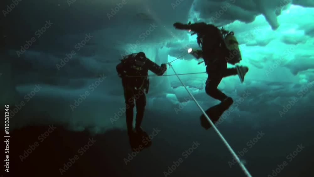 Vidéo Stock Unique extreme underwater shooting scuba dive beneath ice ...