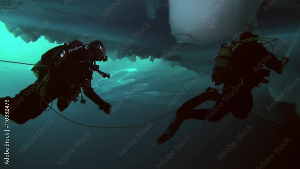 Vidéo Stock Unique extreme underwater shooting scuba dive beneath ice ...