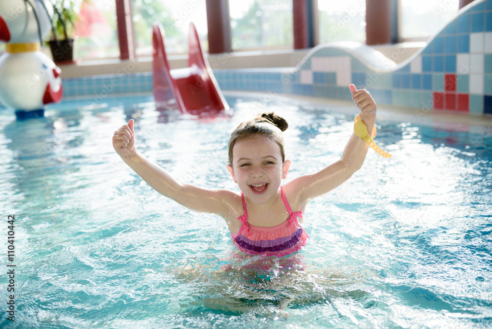 Adorable little girl playing with water splashes at indoor pool Stock ...