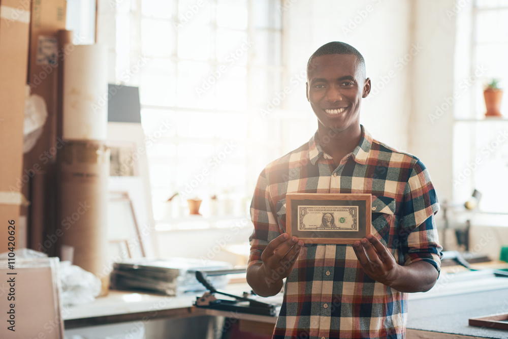 Smiling African entrepreneur showing his first dollar bill earned Stock ...