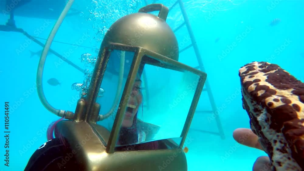 Girl in the helmet looks at sea creatures at the Bermuda Helmet Diving ...