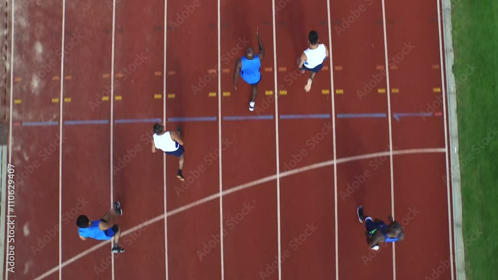 Aerial view of track athletes at running track, competing in a race ...