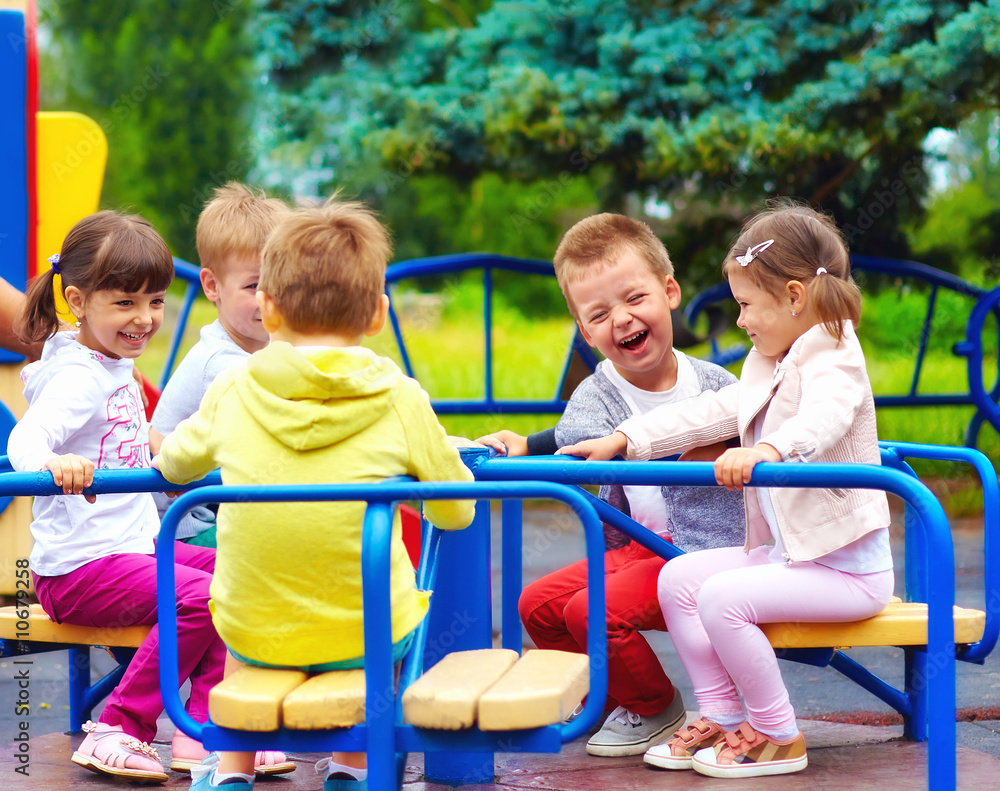 happy kids having fun on roundabout at playground Stock Photo | Adobe Stock