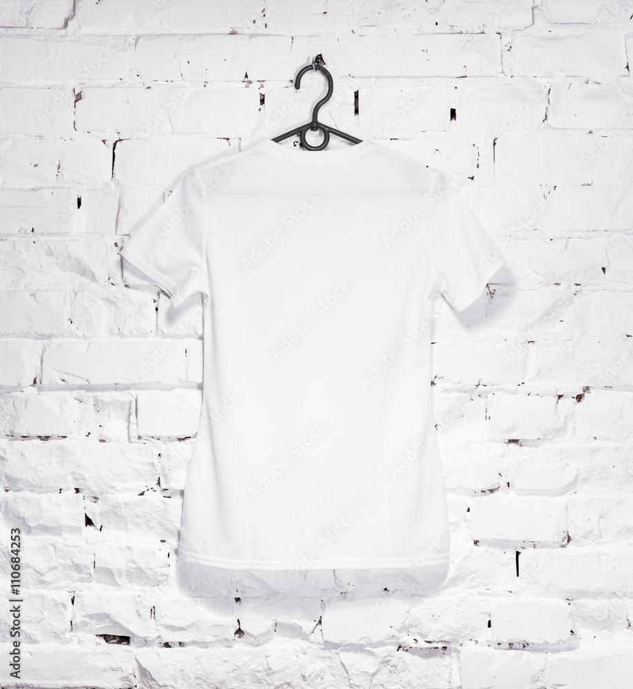 texture of brick whitewashed wall with white woman shirt on hanger ...