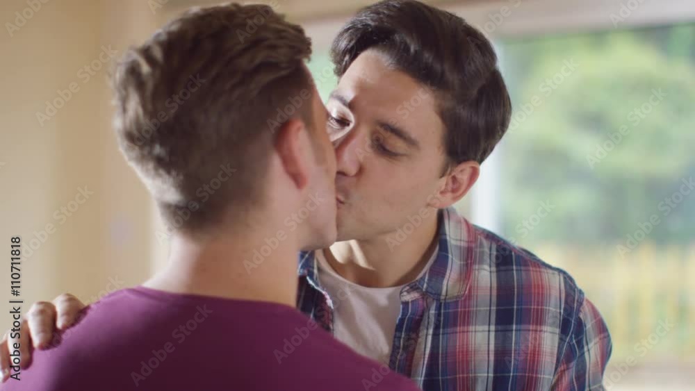 Attractive young gay couple share a kiss as they're chatting at home vídeo de Stock | Adobe Stock