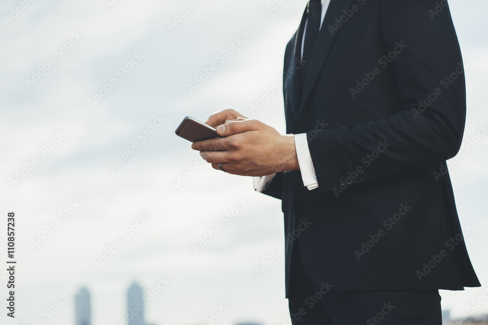 Professional employer using modern smartphone outside, close-up image ...
