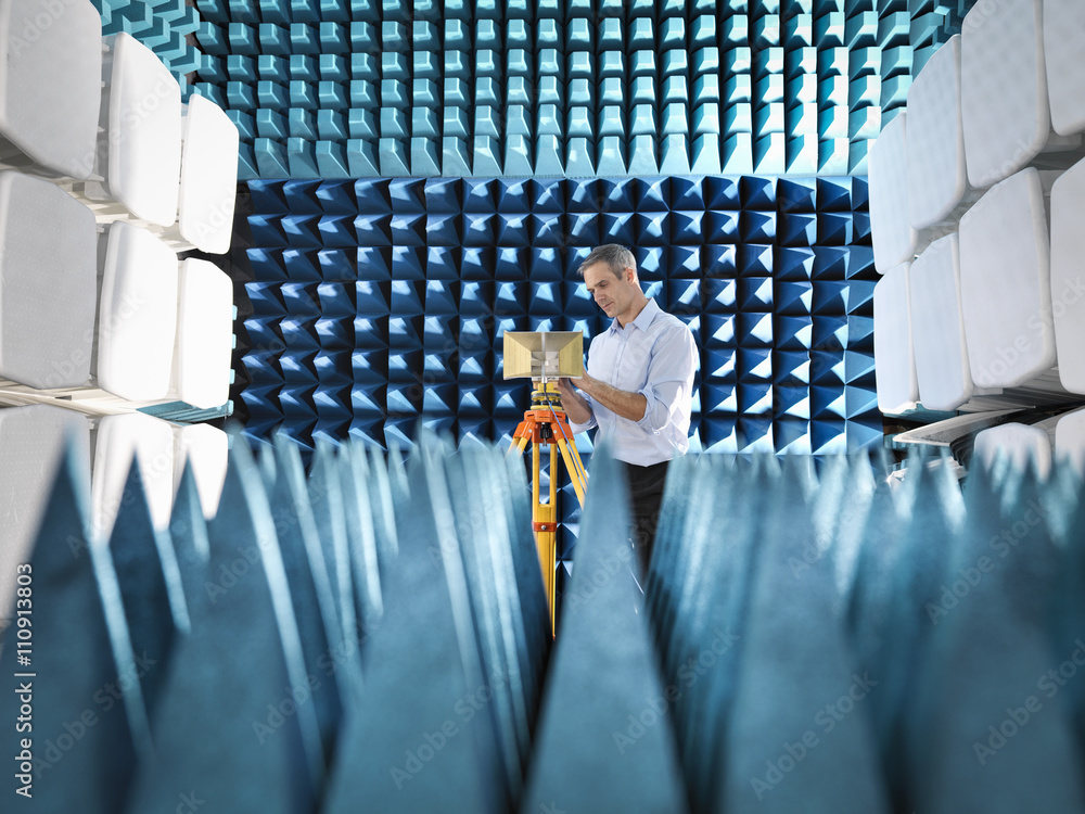 Male scientist preparing to measure electromagnetic waves in anechoic ...