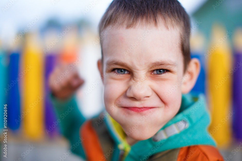 aggressive child raised his fist to strike. boy contorted with anger ...