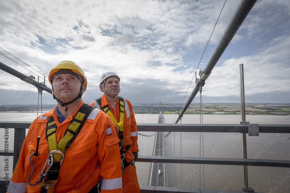Portrait of bridge workers on top of suspension bridge. The Humber ...