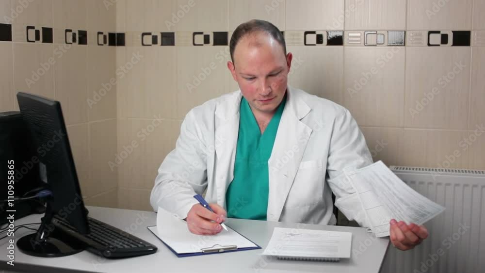 Male caucasian surgeon make notes in medical history in office. Medical ...