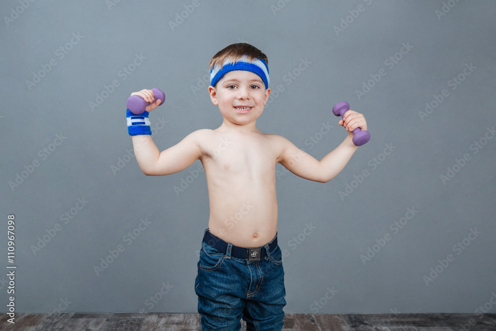 Happy cute little boy standing and doing exercises with dumbbells Stock ...