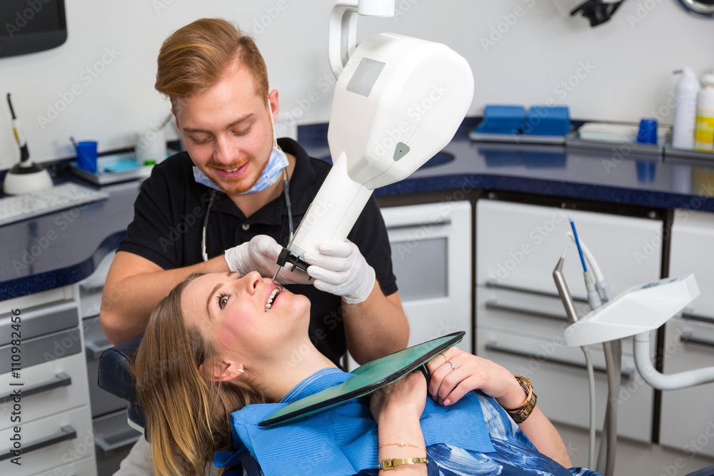 Dentist or radiologist scanning teeth of patient with x-ray apparatus ...