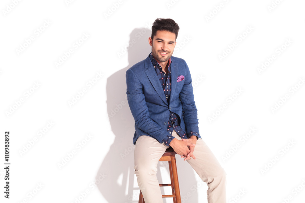 smiling relaxed man in suit sitting on a stool Stock Photo | Adobe Stock