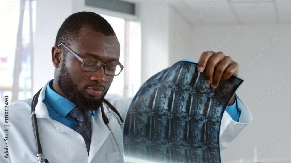 Vidéo Stock African american male radiologist viewing mri scan of spine ...